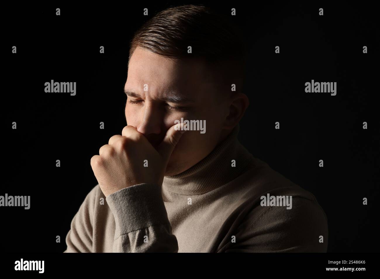 Distressed young man crying on black background Stock Photo - Alamy
