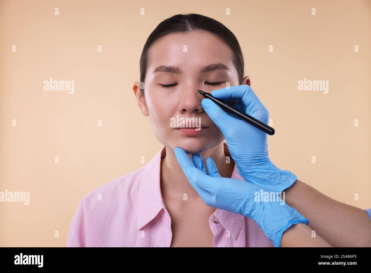 Doctor drawing marks on patient's nose for plastic surgery operation ...