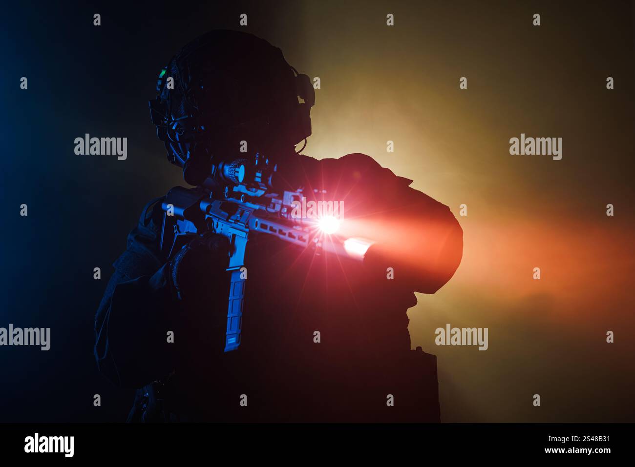 A tactical professional in full gear aiming a rifle with attached ...