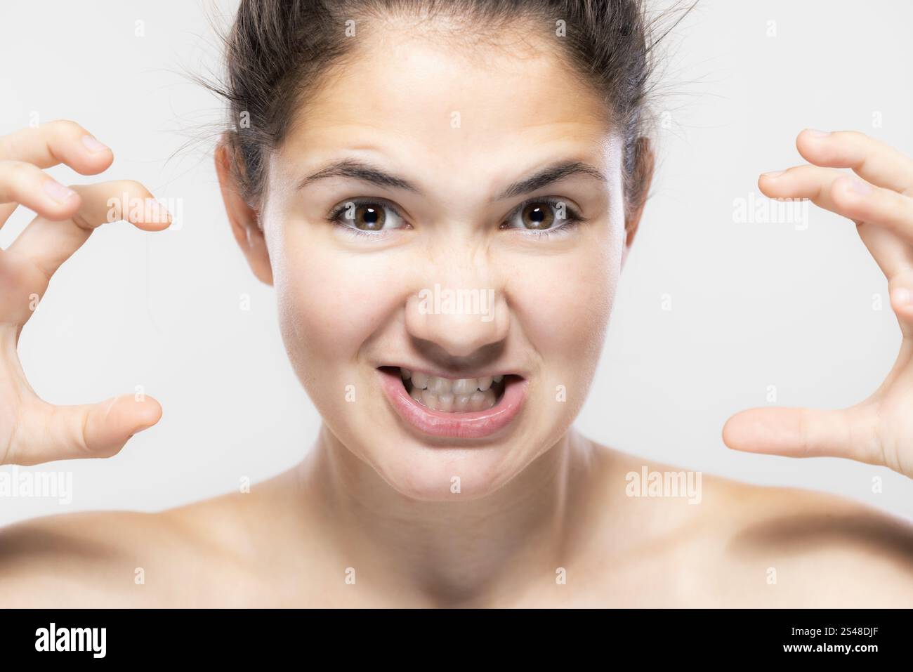 This engaging close-up captures a young woman playfully making faces ...