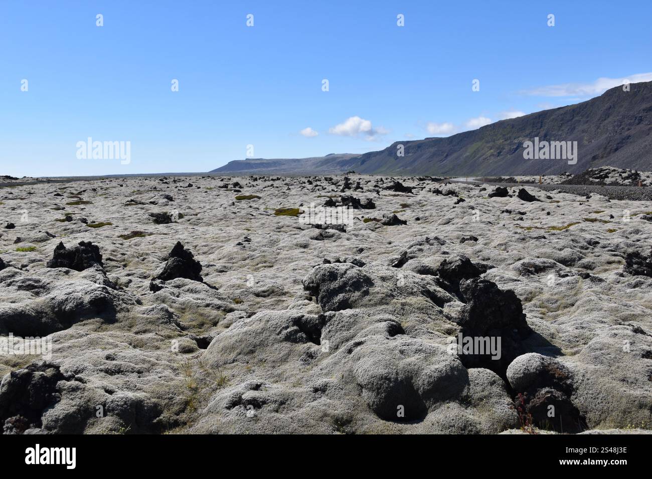 South Coast Iceland landscape by ocean with lava rock covered in white ...