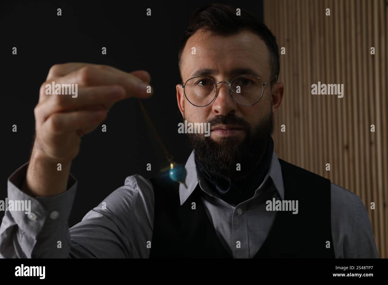 Hypnosis session. Man in glasses swinging pendulum indoors Stock Photo ...