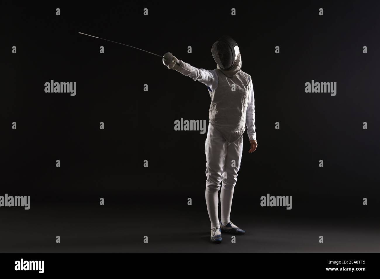 Fencer with epee practicing on dark background Stock Photo - Alamy