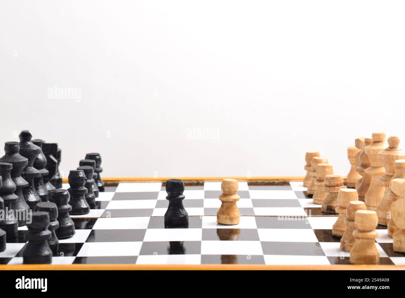 White chess pieces face off black chess pieces on white background ...