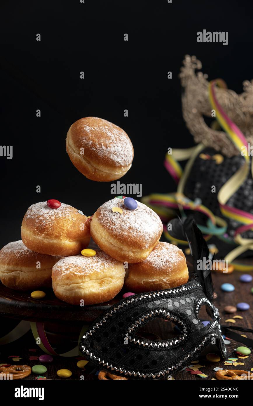 Berliners, doughnuts with icing sugar and Smarties next to a black mask, carnival Stock Photo ...