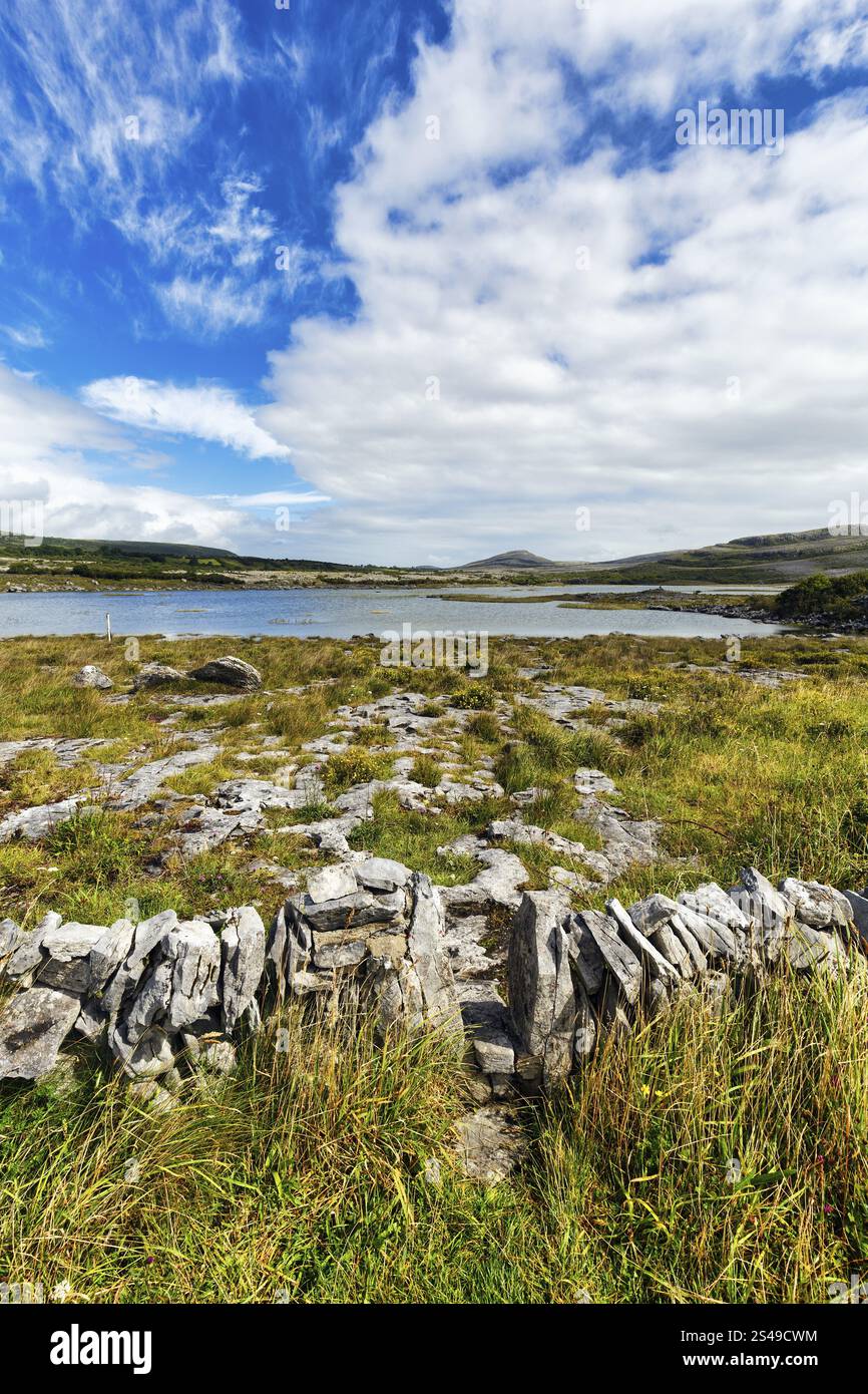 Hiking trail leads through stone wall, boundary, karst landscape, lake ...