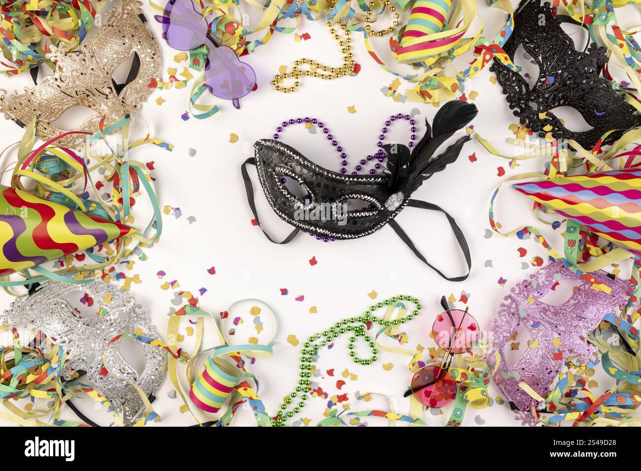 Colourful masks, paper streamers, confetti and party hats on a white ...