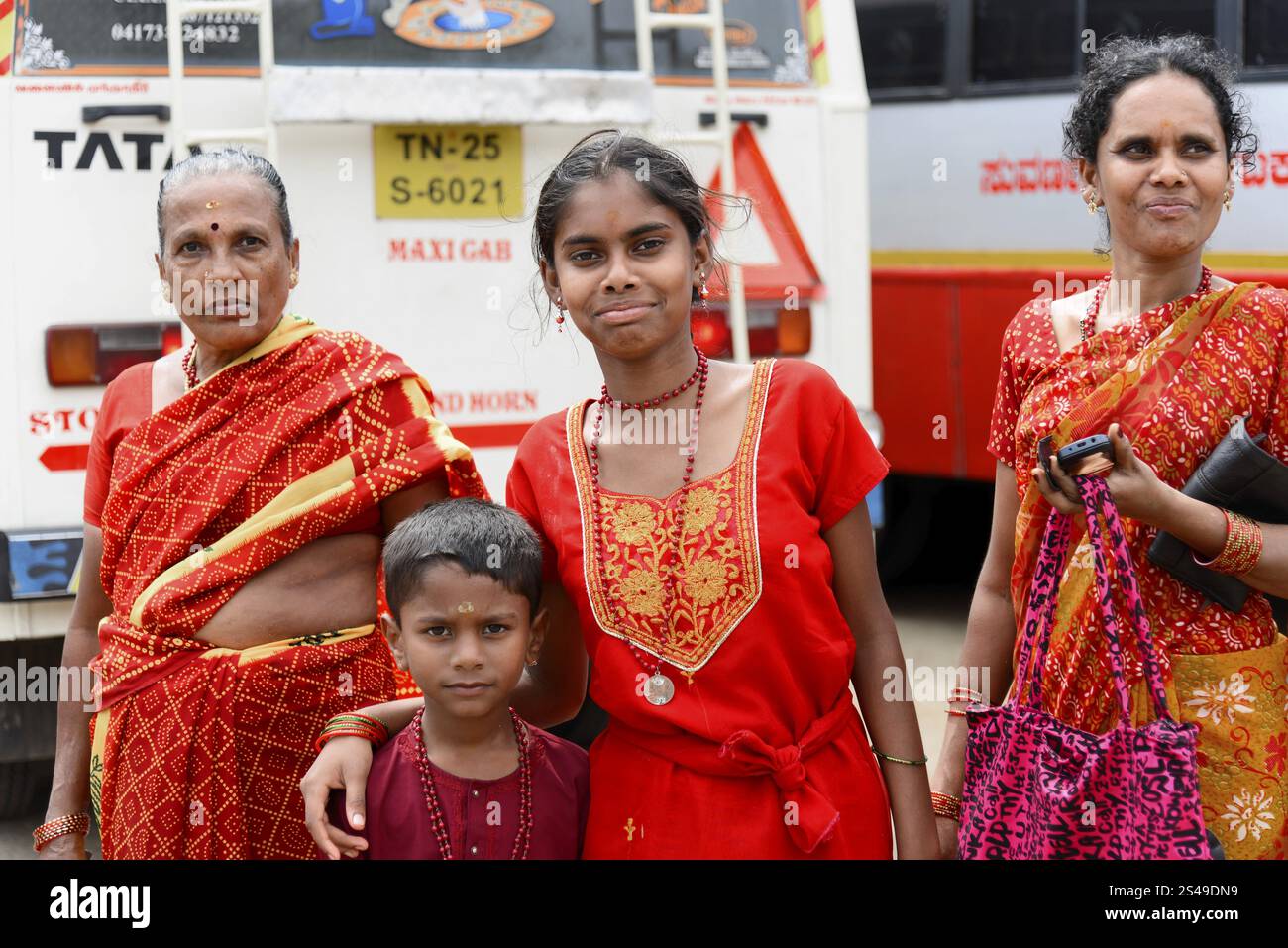Group of people in traditional red clothes in front of a bus ...