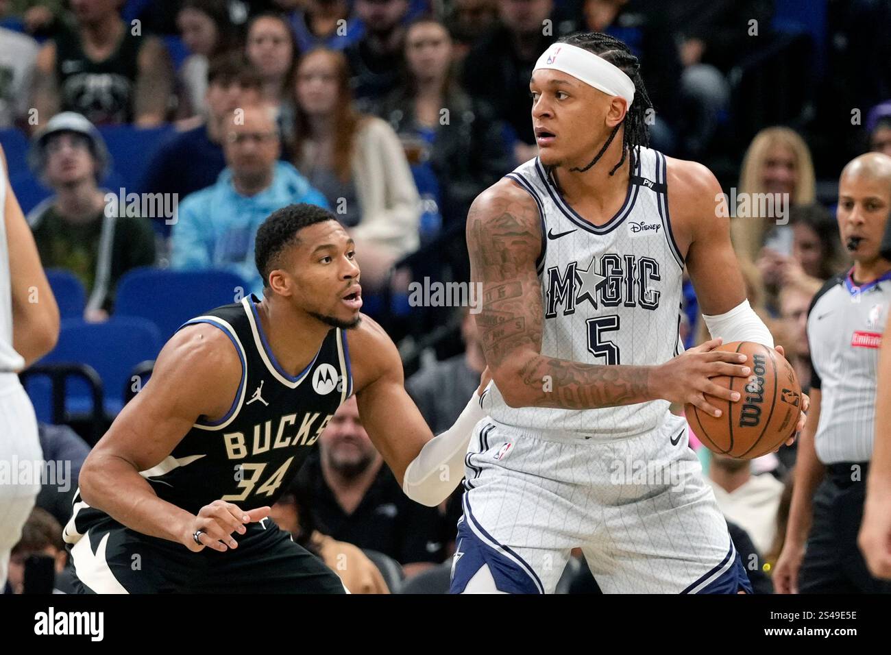 Orlando Magic forward Paolo Banchero (5) looks to pass the ball as Milwaukee Bucks forward ...