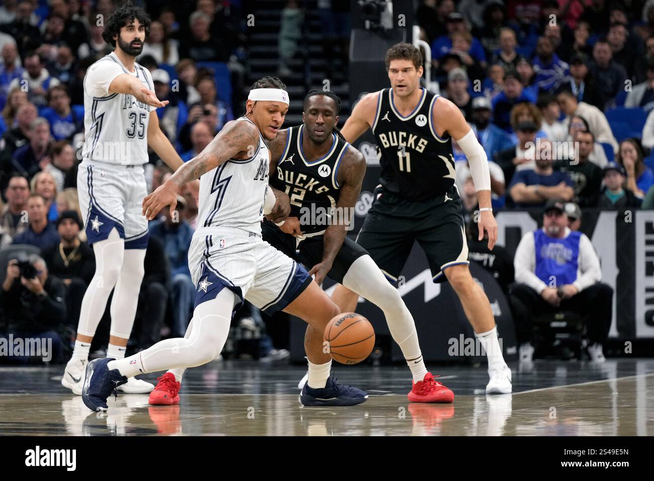 Orlando Magic forward Paolo Banchero, center, goes after a loose ball in front of Milwaukee ...