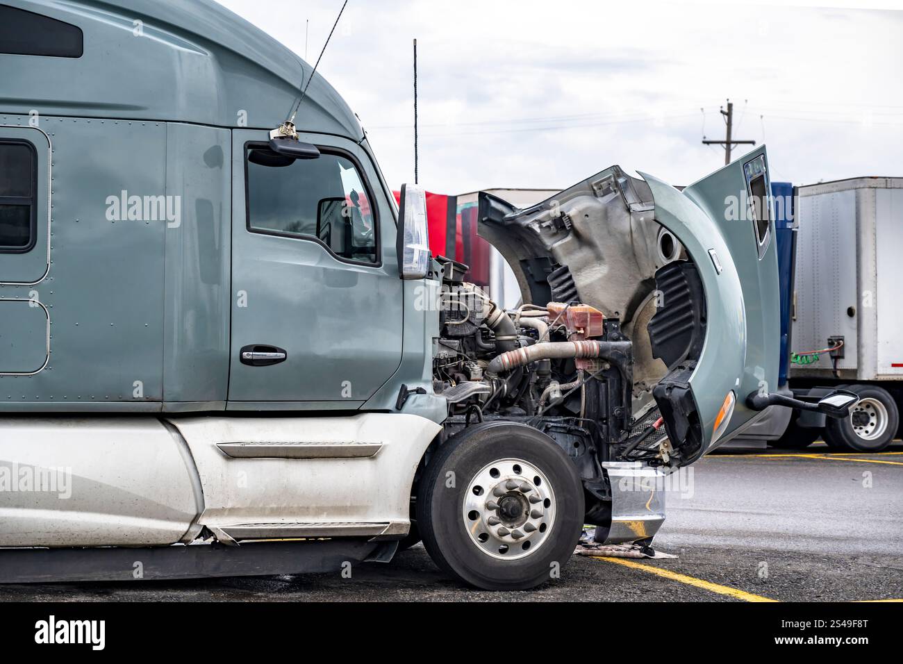Broken big rig gray semi truck with open hood standing on truck stop ...