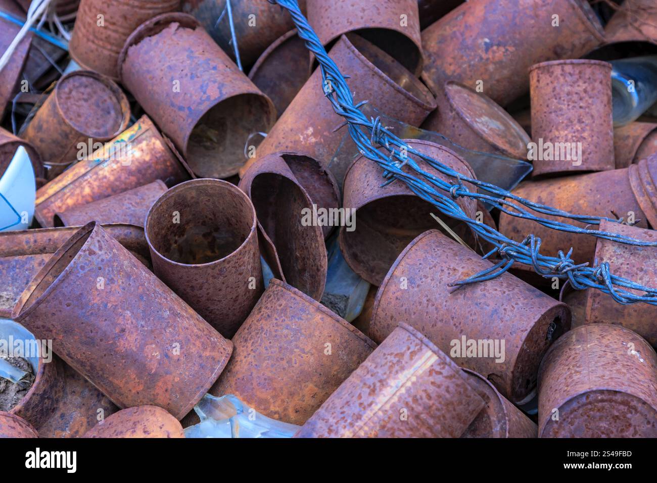 A pile of rusty cans and broken glass. Scene is one of decay and ...
