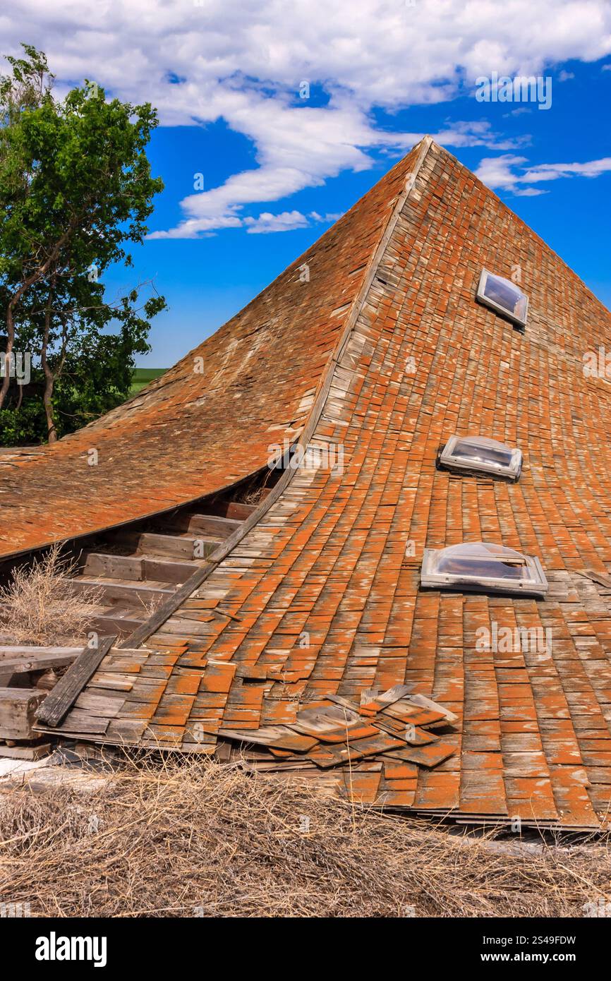 A pyramid shaped building with a red roof and four windows. The roof is ...