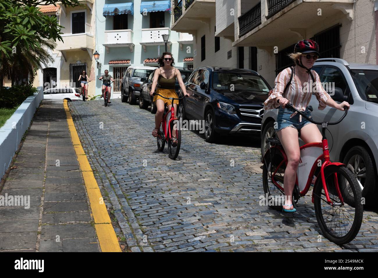 San Juan, Puerto Rico - February 25, 2018: Tourists bicycle down steep ...