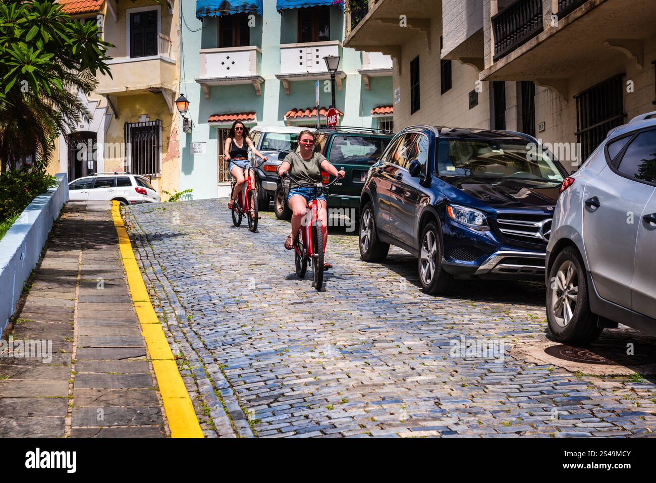 San Juan, Puerto Rico - February 25, 2018: Tourists bicycle down steep ...