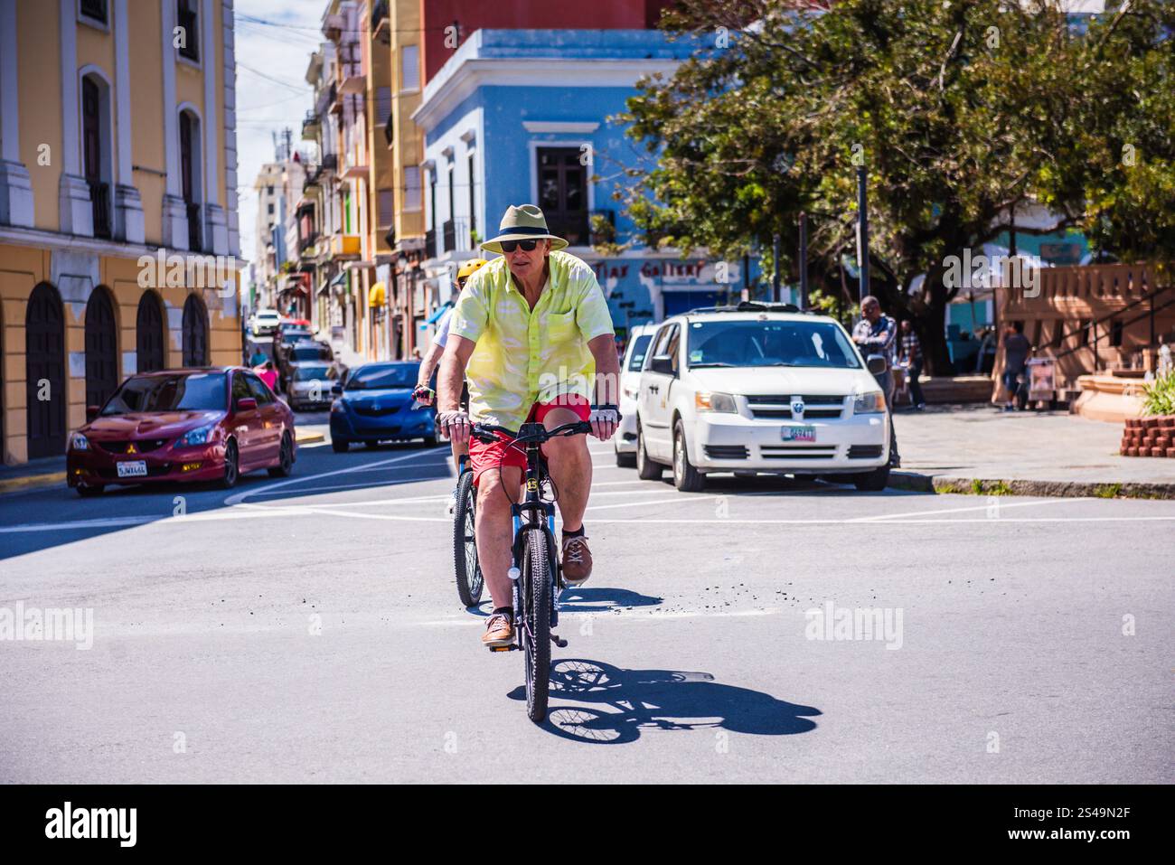 San Juan, Puerto Rico - February 26, 2018: A couple of tourists bike past Plaza Colon in Old San ...
