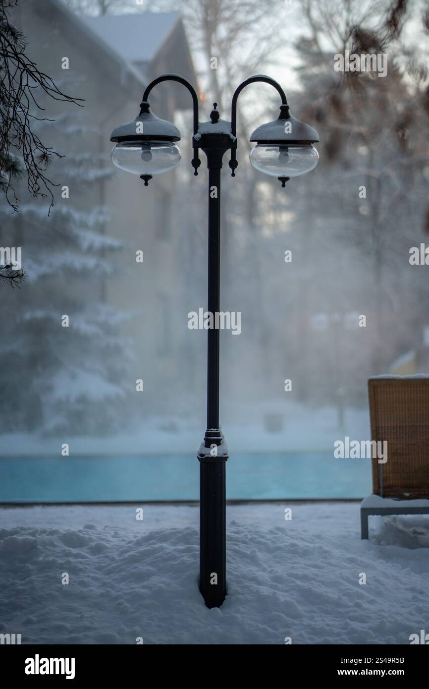 Street lamp near warm swimming pool, loungers in cold weather. Winter wellness spa resort Stock ...