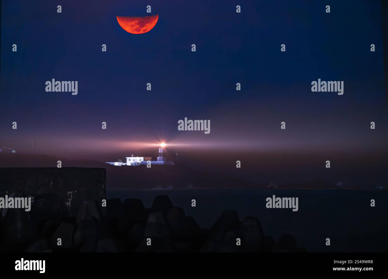 A bright red moon illuminates the night sky above the Fugui Cape ...