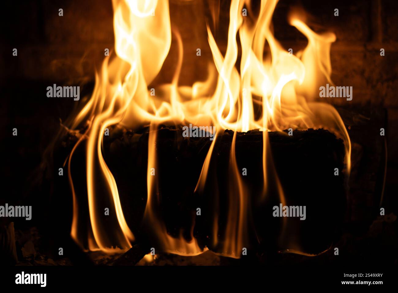 A mesmerizing image of a roaring fire in a fireplace, casting a warm ...