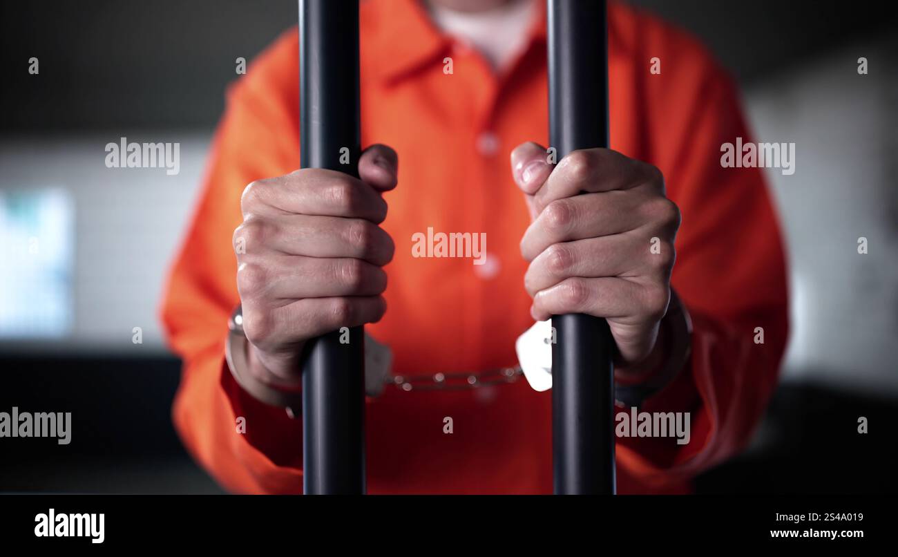 Prisoner Behind Bars In Jail Cell. Crime Punishment And Criminal Justice Stock Photo - Alamy
