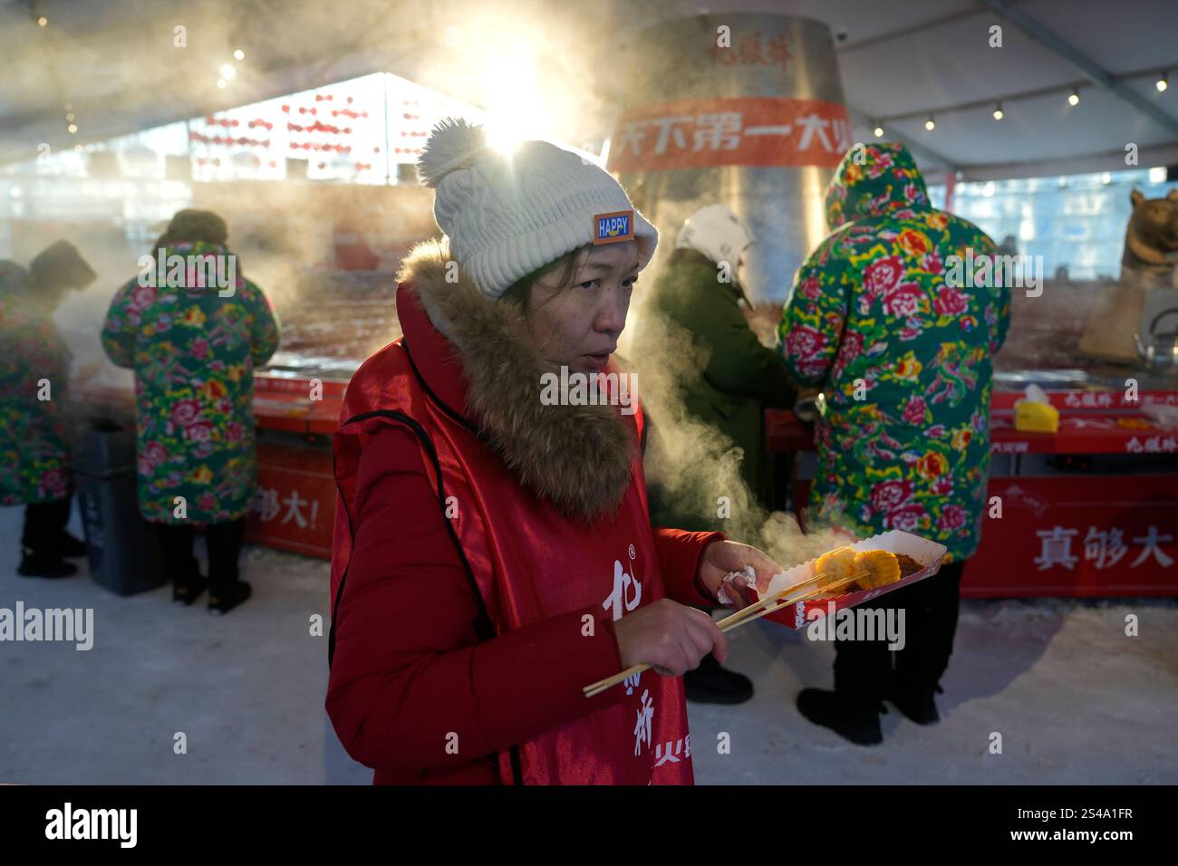 A woman eats hot food to keep warm at a giant hotpot restaurant inside ...