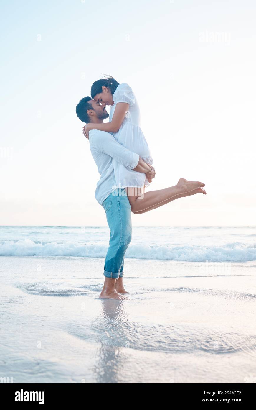 Couple, hug and lift at beach, love and vacation for connection in low ...