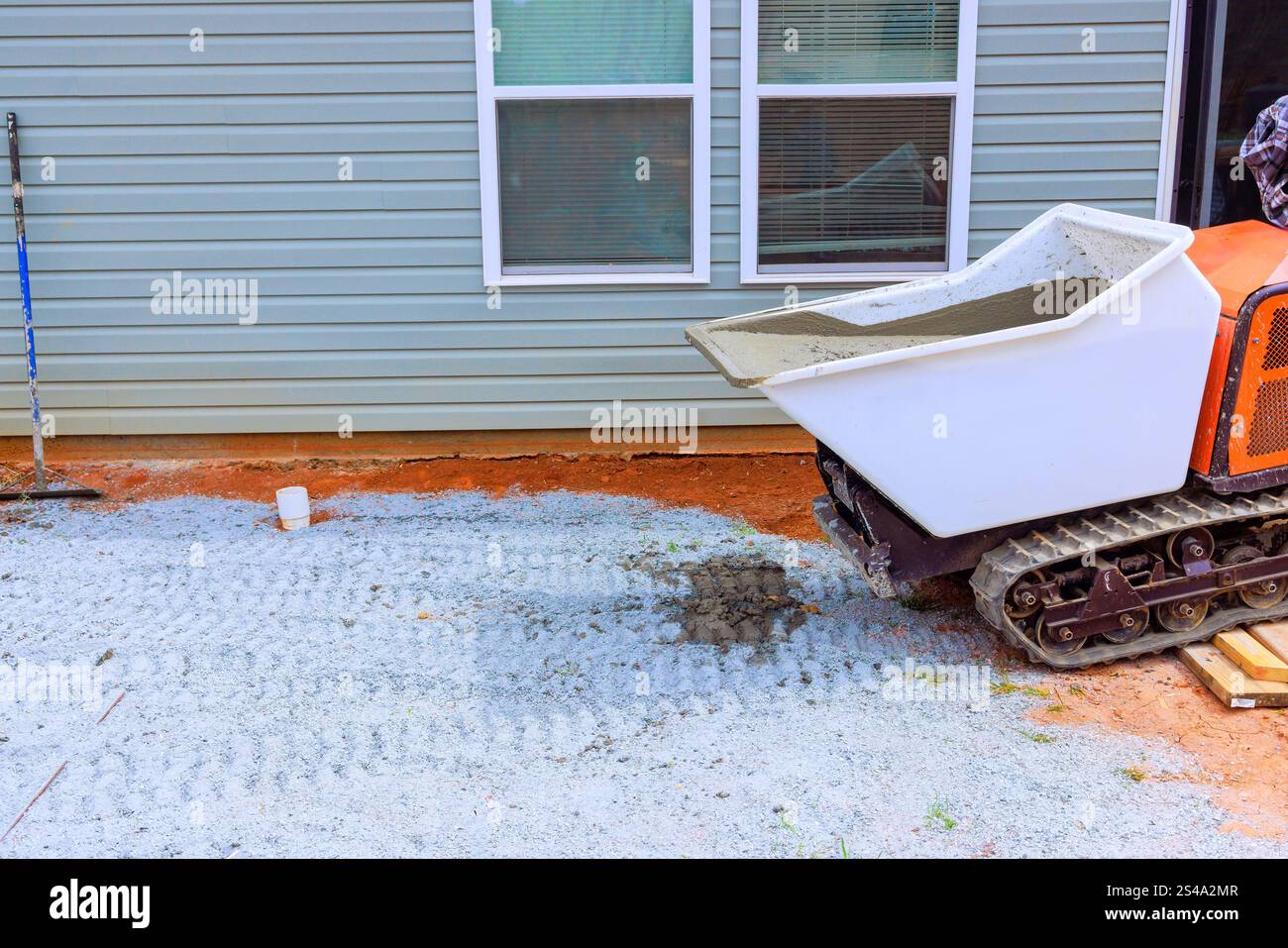 Rubber tracked dumper moves concrete for foundation slab to building ...