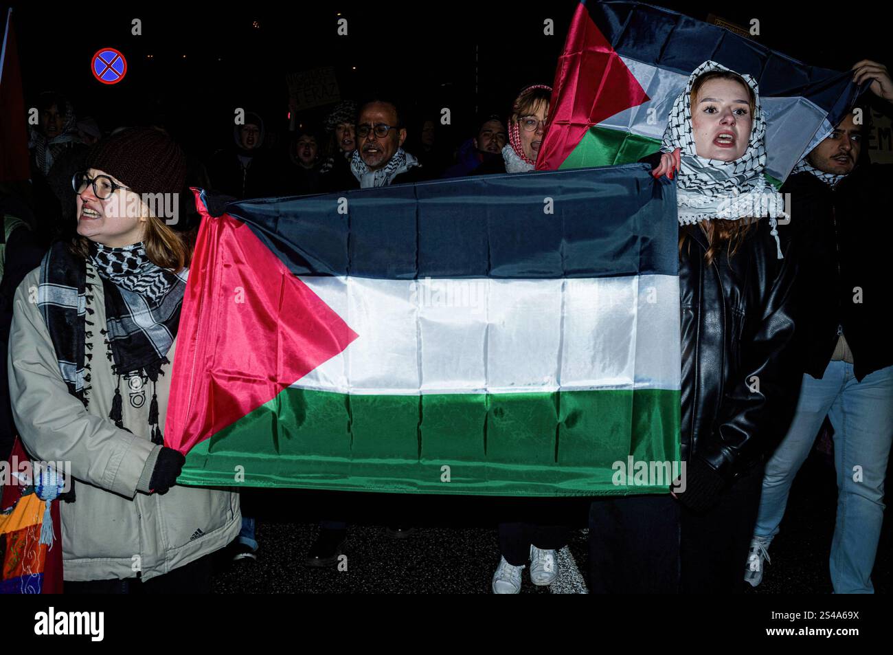 Protesters carry a Palestinian flag and chant slogans with the crowd ...
