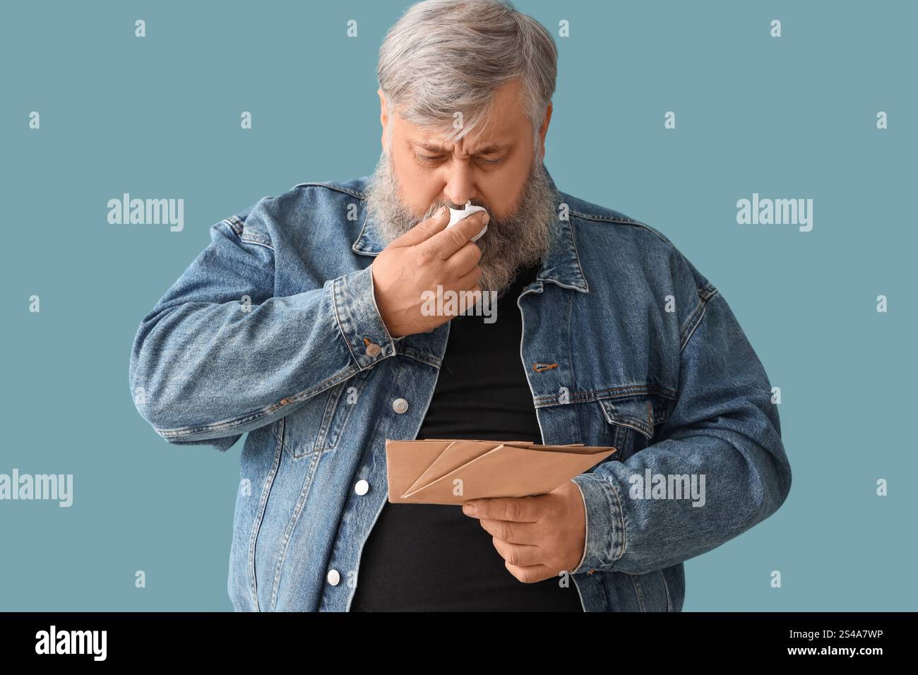 Portrait of sad senior man reading letter on blue background Stock ...