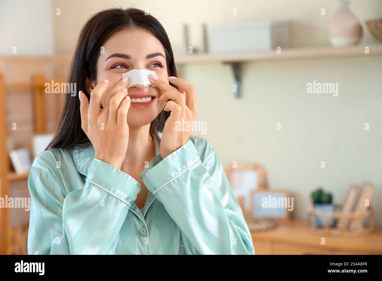 Young woman applying nose patch in bedroom Stock Photo - Alamy