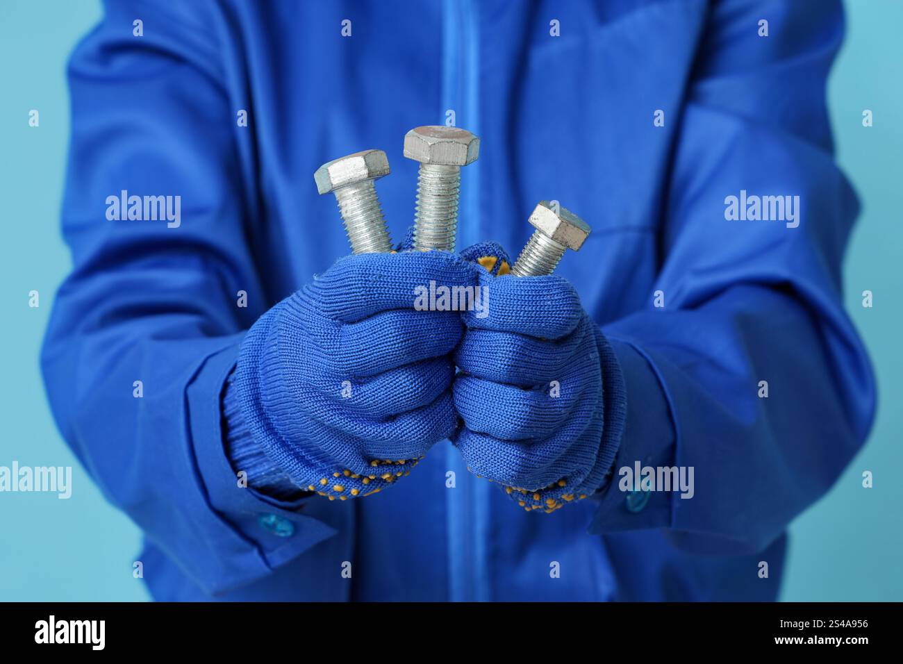 Mechanic with bolts on blue background, closeup Stock Photo - Alamy