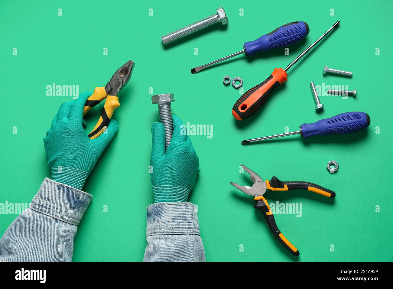 Mechanic's hands with bolt and tools on green background Stock Photo ...