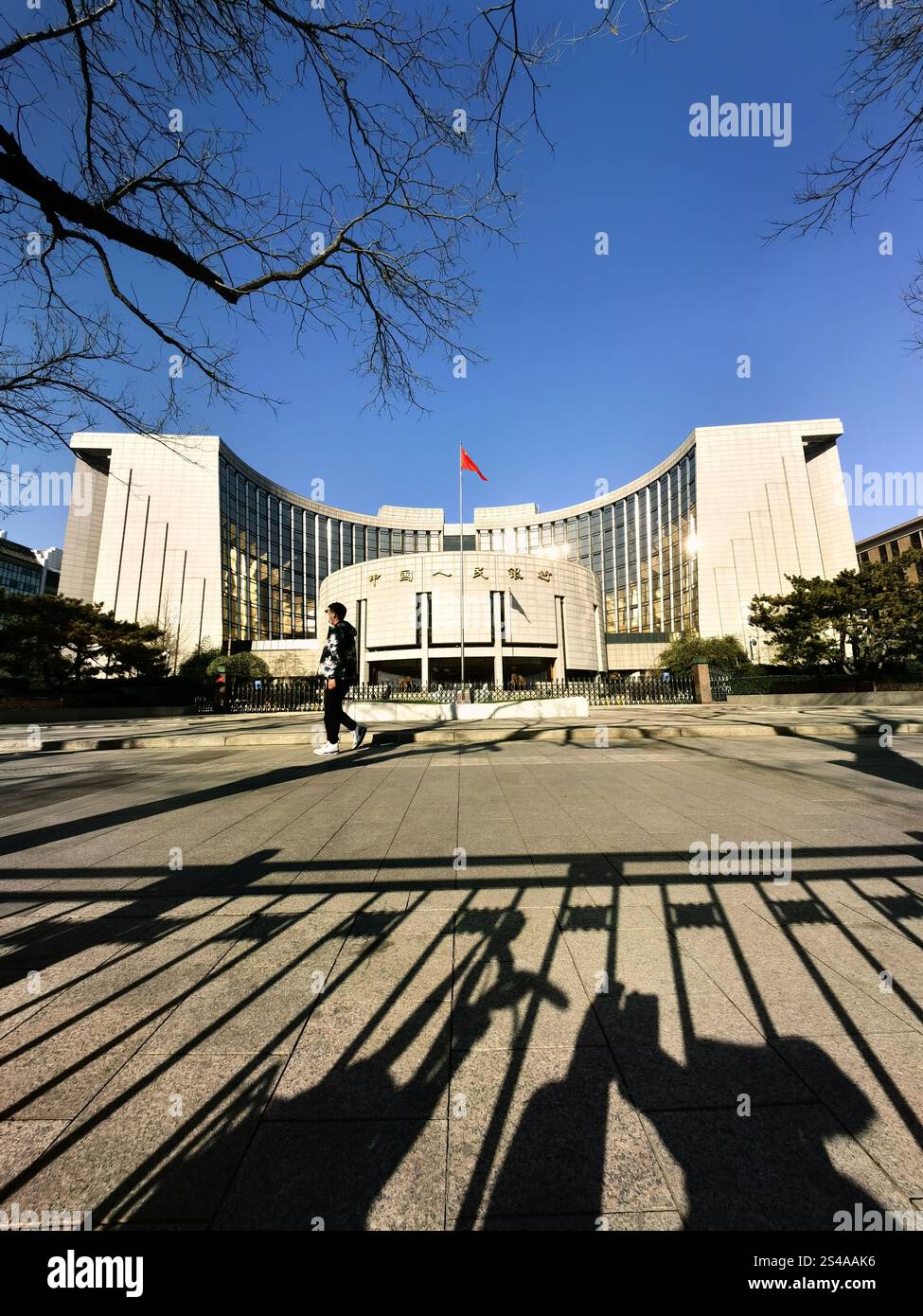 A citizen passes the headquarters building of the People's Bank of ...