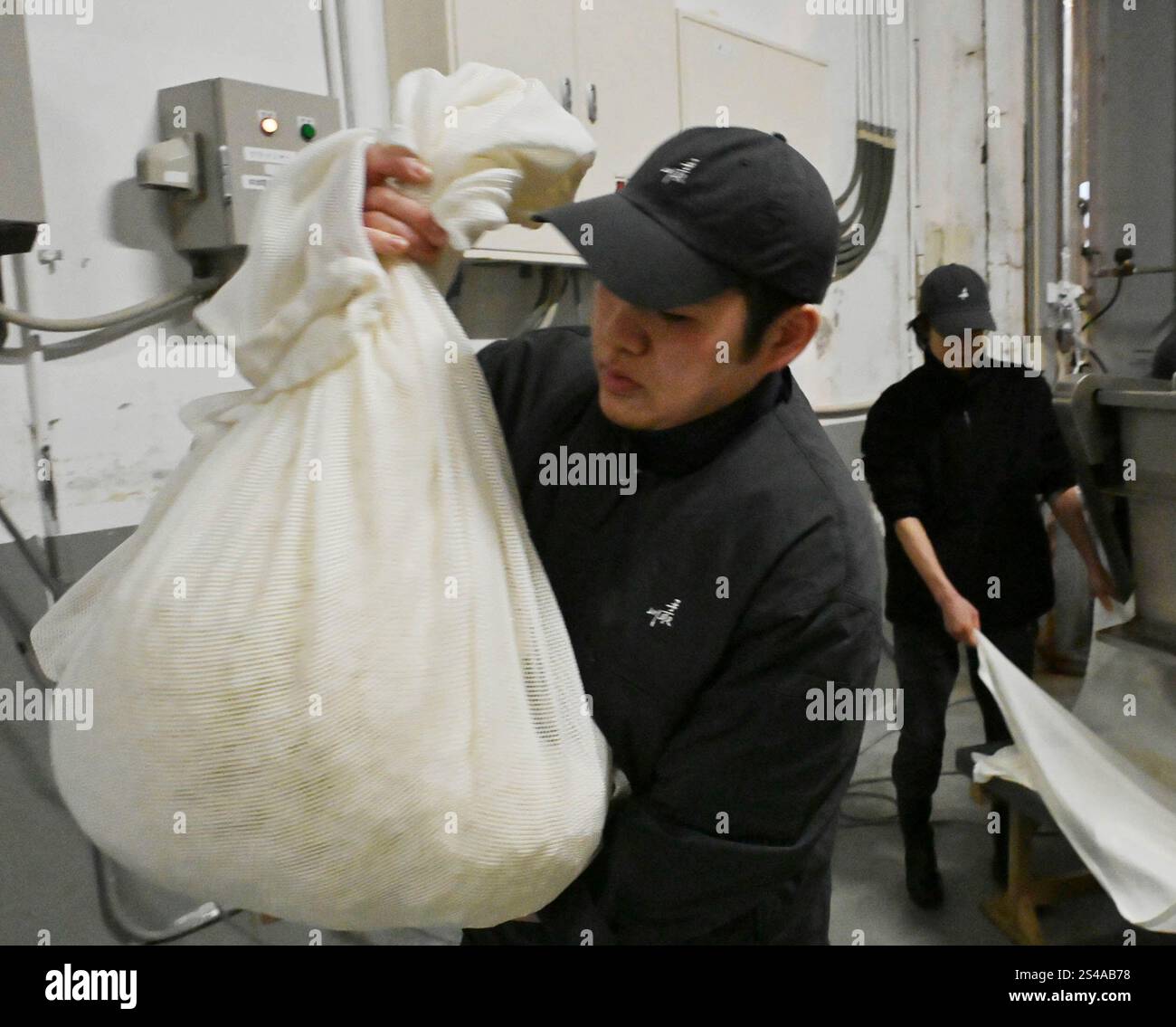 Kurabito brewers carry steamed rice to an yeast mash room at Yoshida ...