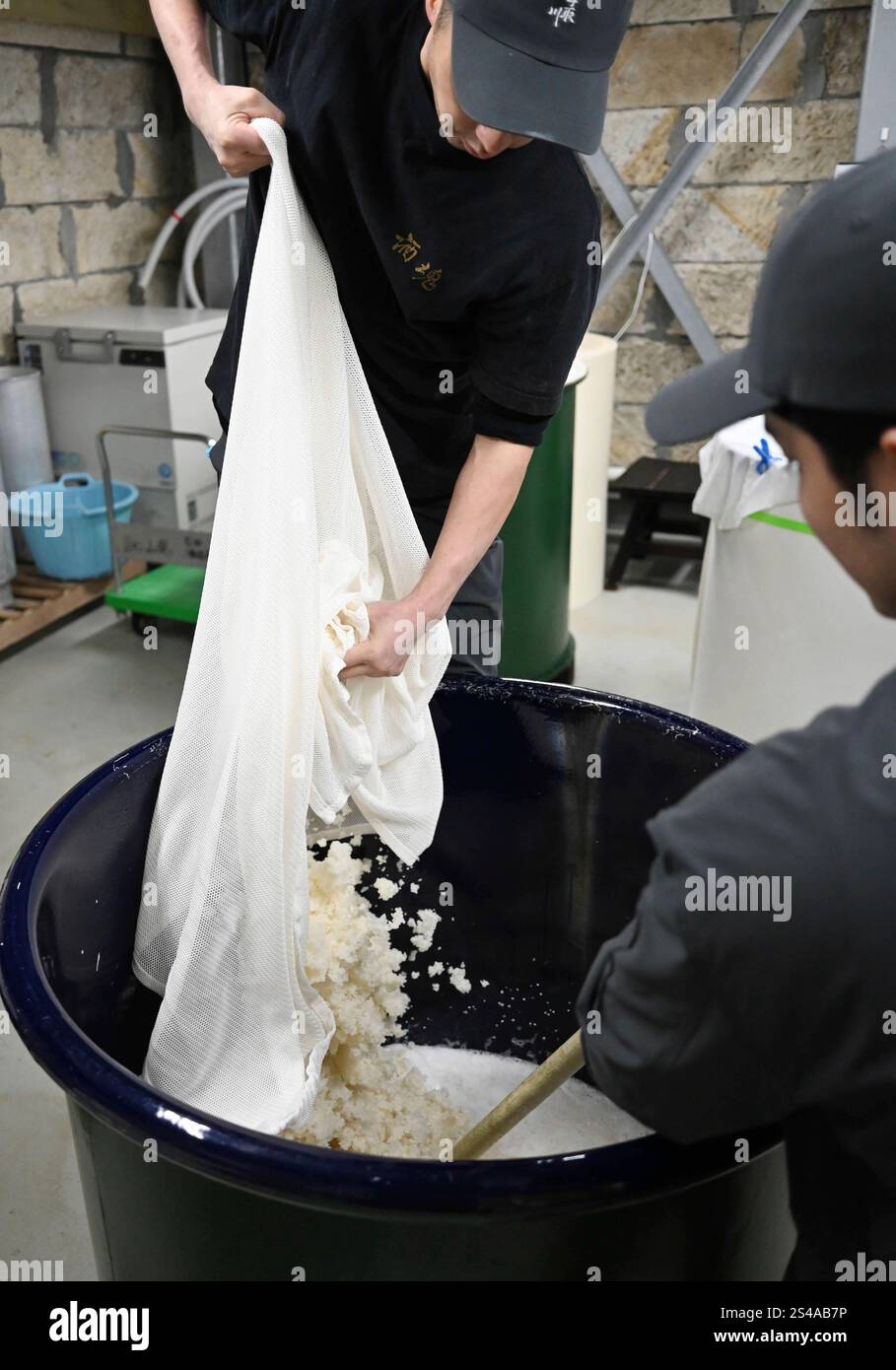 Steamed rice, rice koji and water are mixed to brew yeast mash at ...