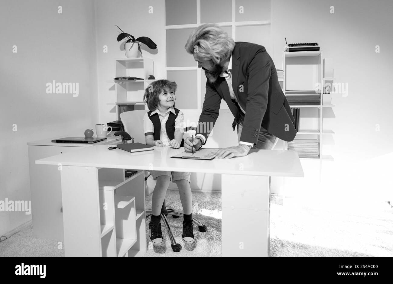 Little boy playing to be boss on a business desk in office. Business ...