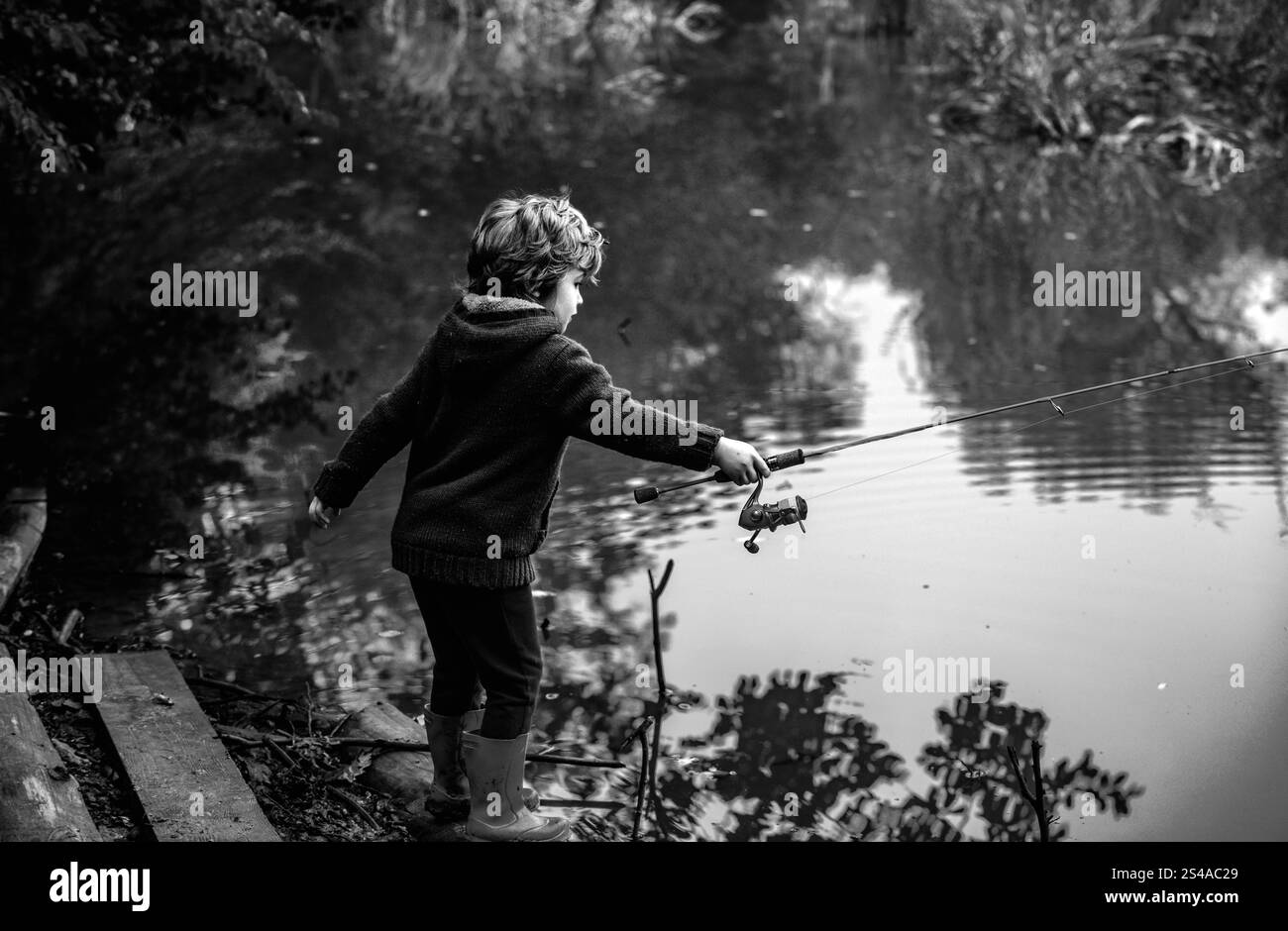 Cute child little boy pulling rod while fishing on lake Stock Photo - Alamy