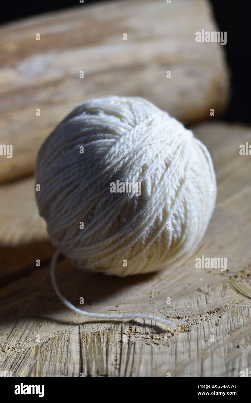 White yarn ball against wood background (vertical Stock Photo - Alamy