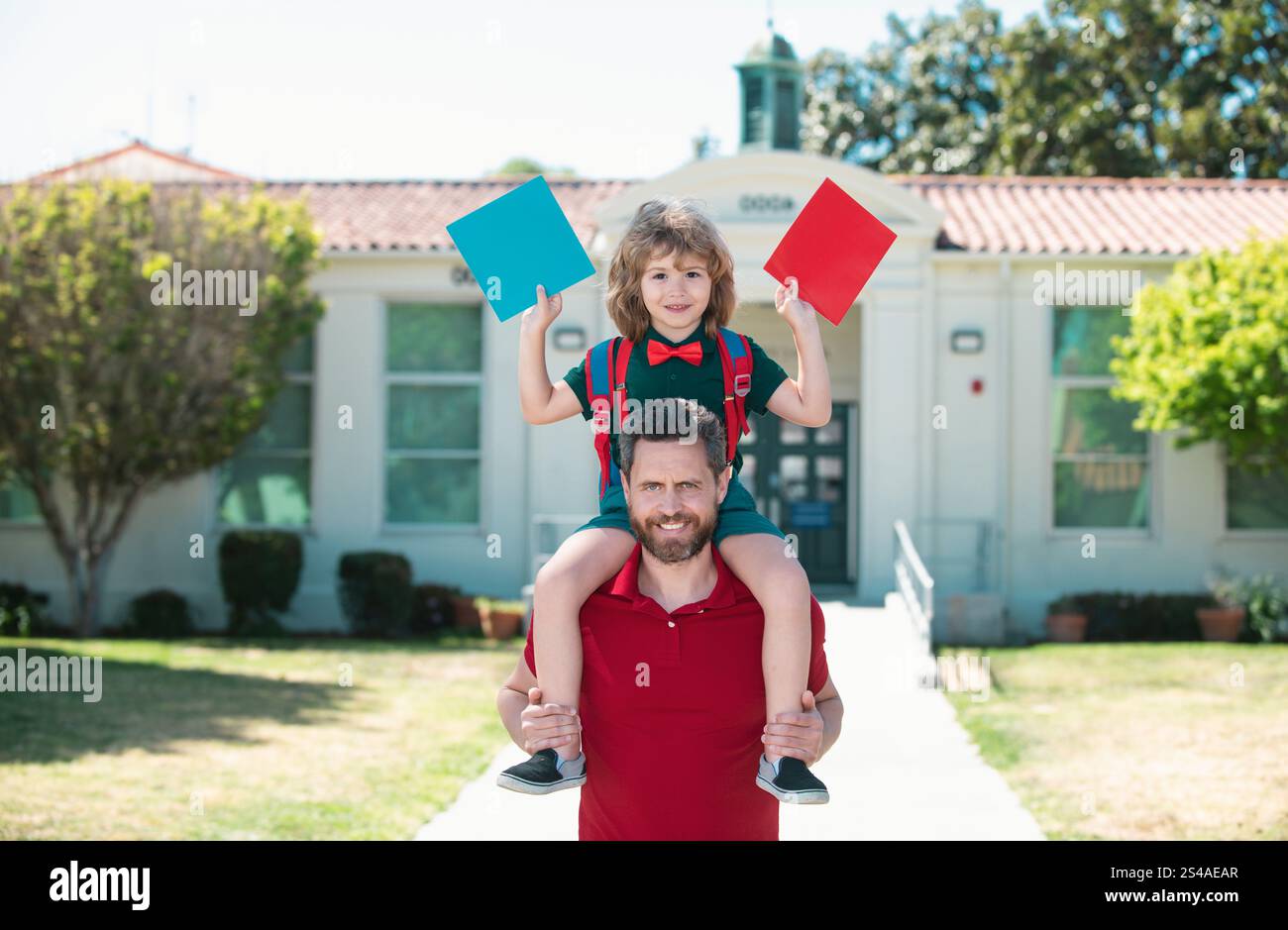 Outdoor school. Father giving son piggyback ride after school ...