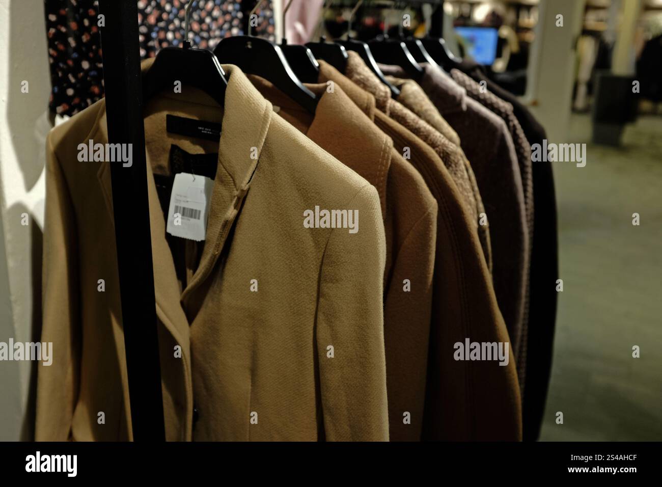 coats hanging on a hangeers on a clothing rack in a store Stock Photo ...
