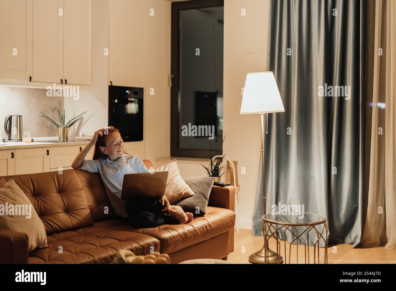 Woman Smiling During a Cozy Video Call at Home, Embracing Long-Distance ...