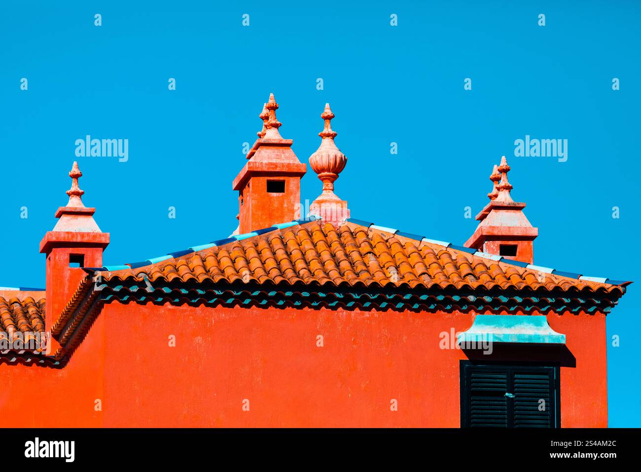 Vivid red building with intricate rooftop details, featuring ornate ...