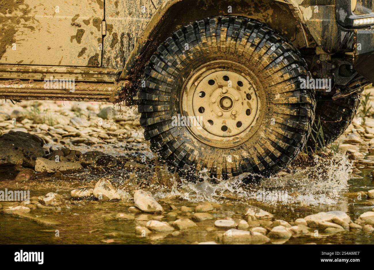 Off road sport truck between mountains landscape. Bottom view to big offroad car wheel on ...