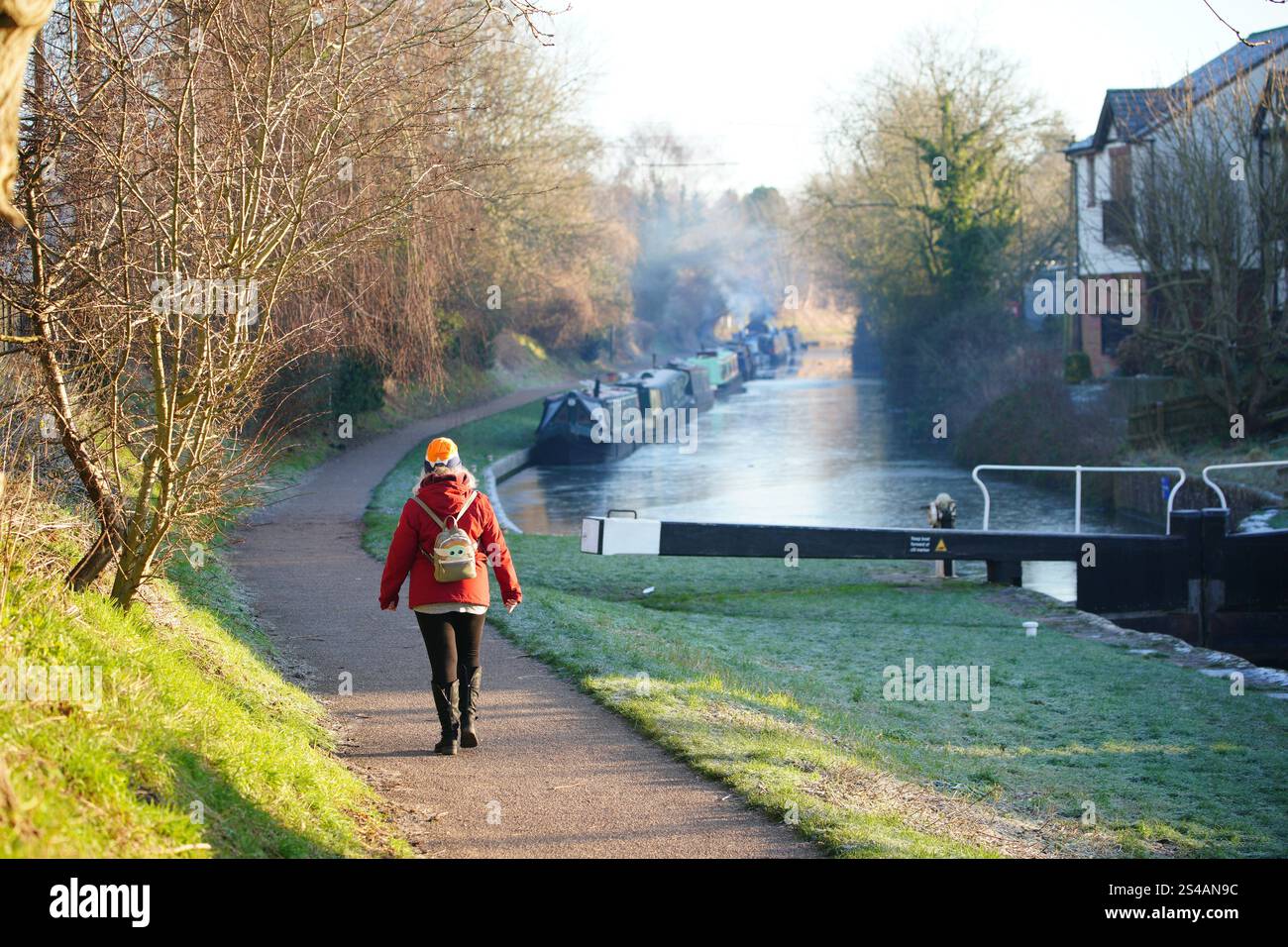 A woman walks along the towpath beside the Kennet and Avon Canal in ...