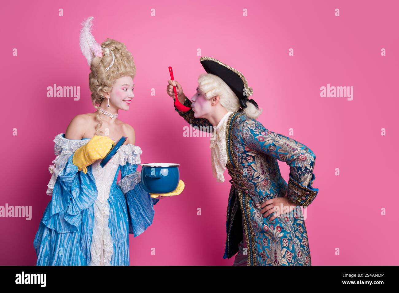 Elegant couple dressed in elaborate baroque costumes against a vibrant ...
