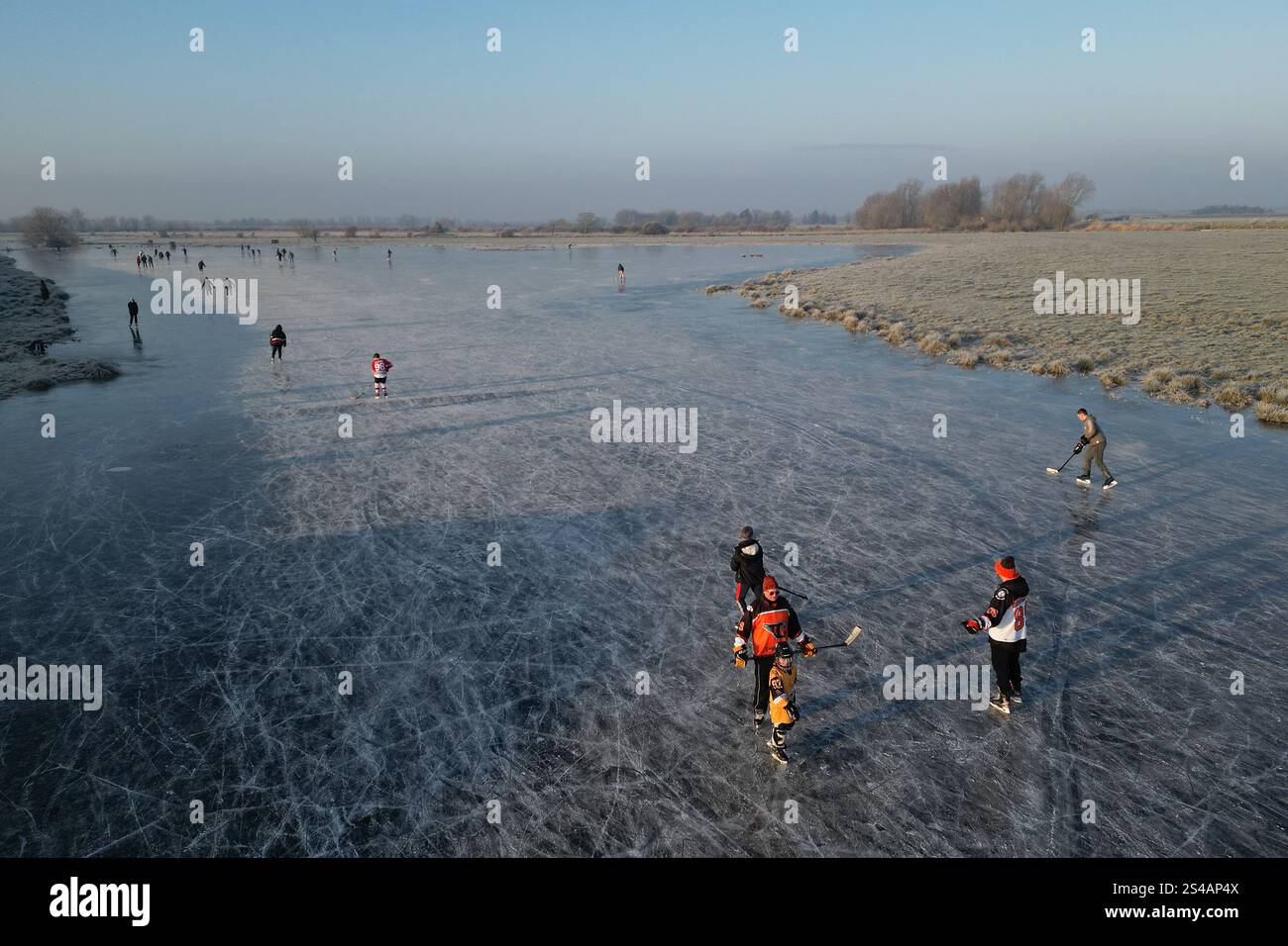 Skaters on a frozen flooded field in Upware, Cambridgeshire. The ...