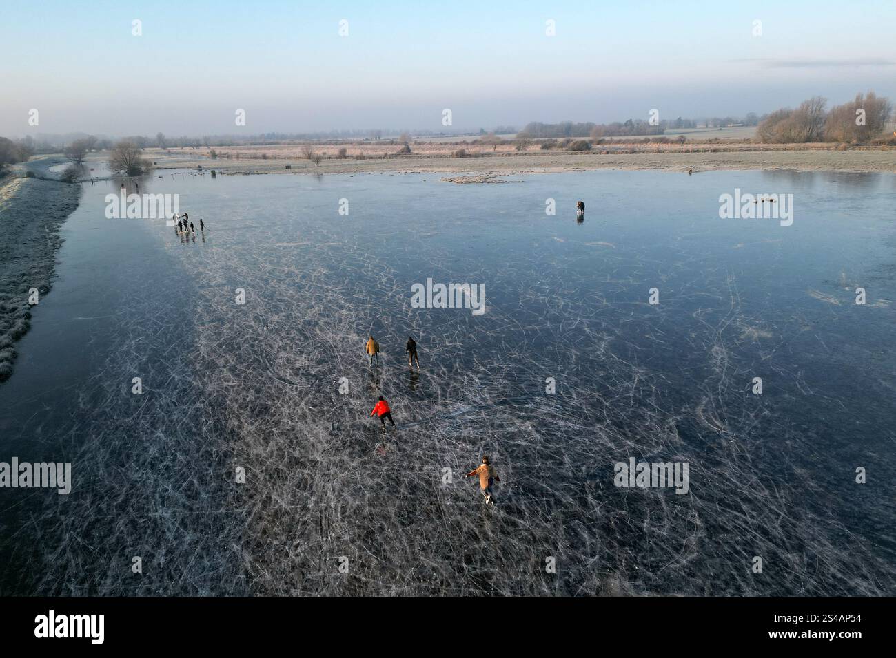 Skaters on a frozen flooded field in Upware, Cambridgeshire. The ...
