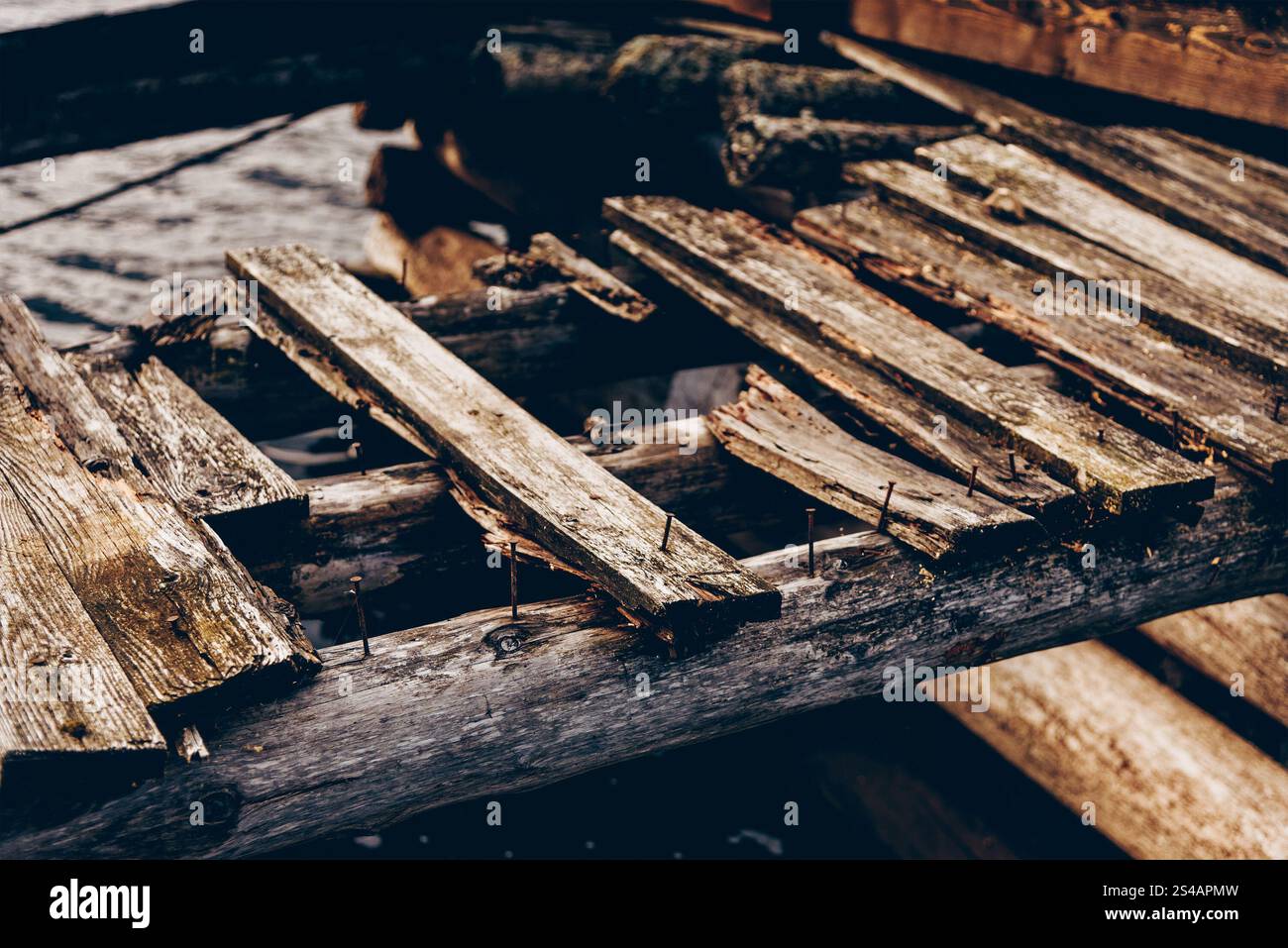 Old rusty nails sticking out of a wooden collapsed bridge, structural ...
