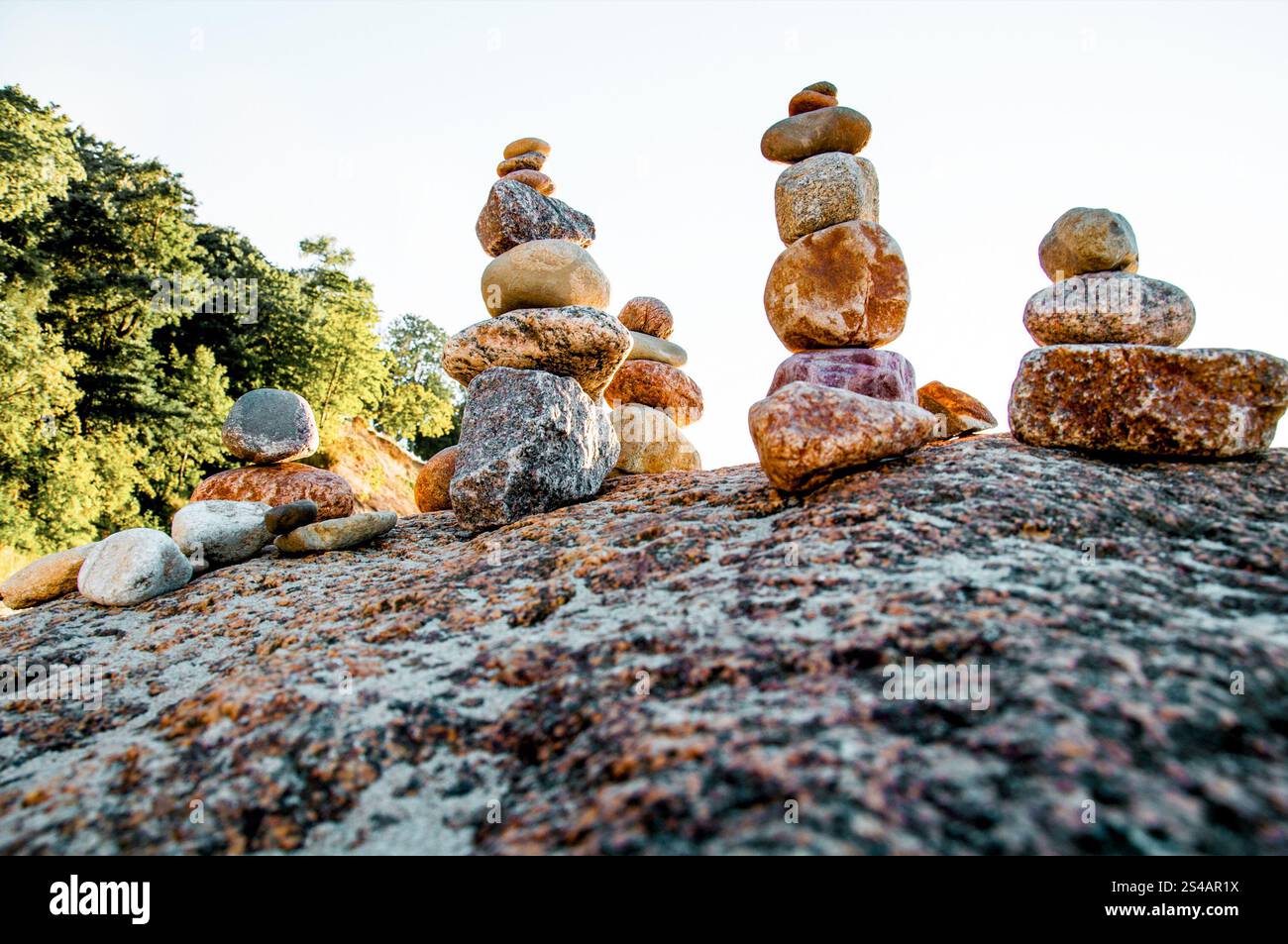 Small stones stacked in pyramids on large cobblestones, zen and balance ...