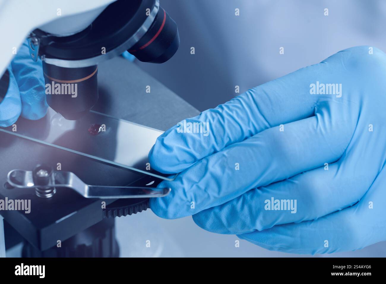 Scientist examining sample on slide under microscope, closeup Stock ...